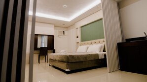 Quarto moderno com cama grande, escrivaninha e parede verde.