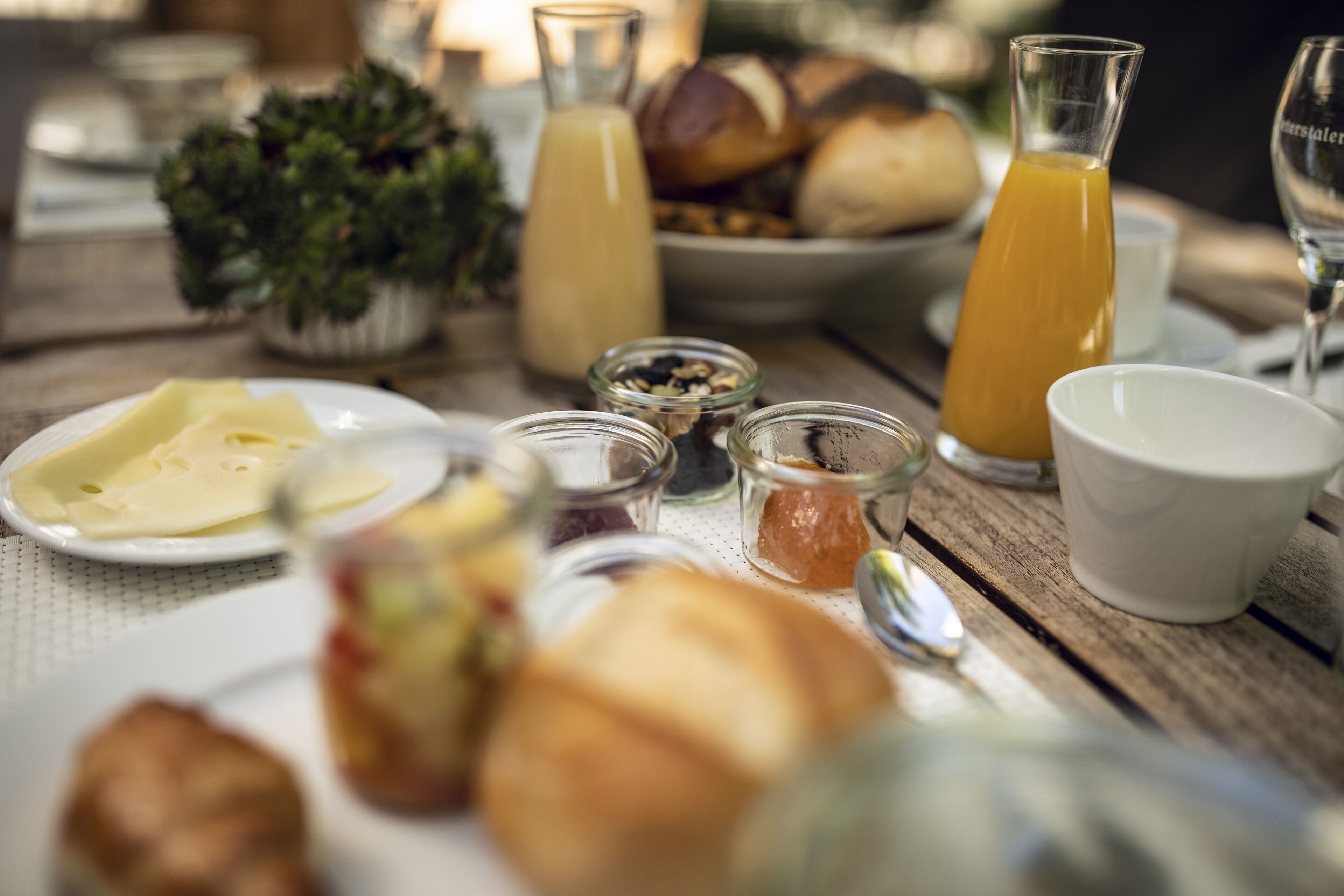 Uma mesa posta para o café da manhã com diversos alimentos e bebidas.