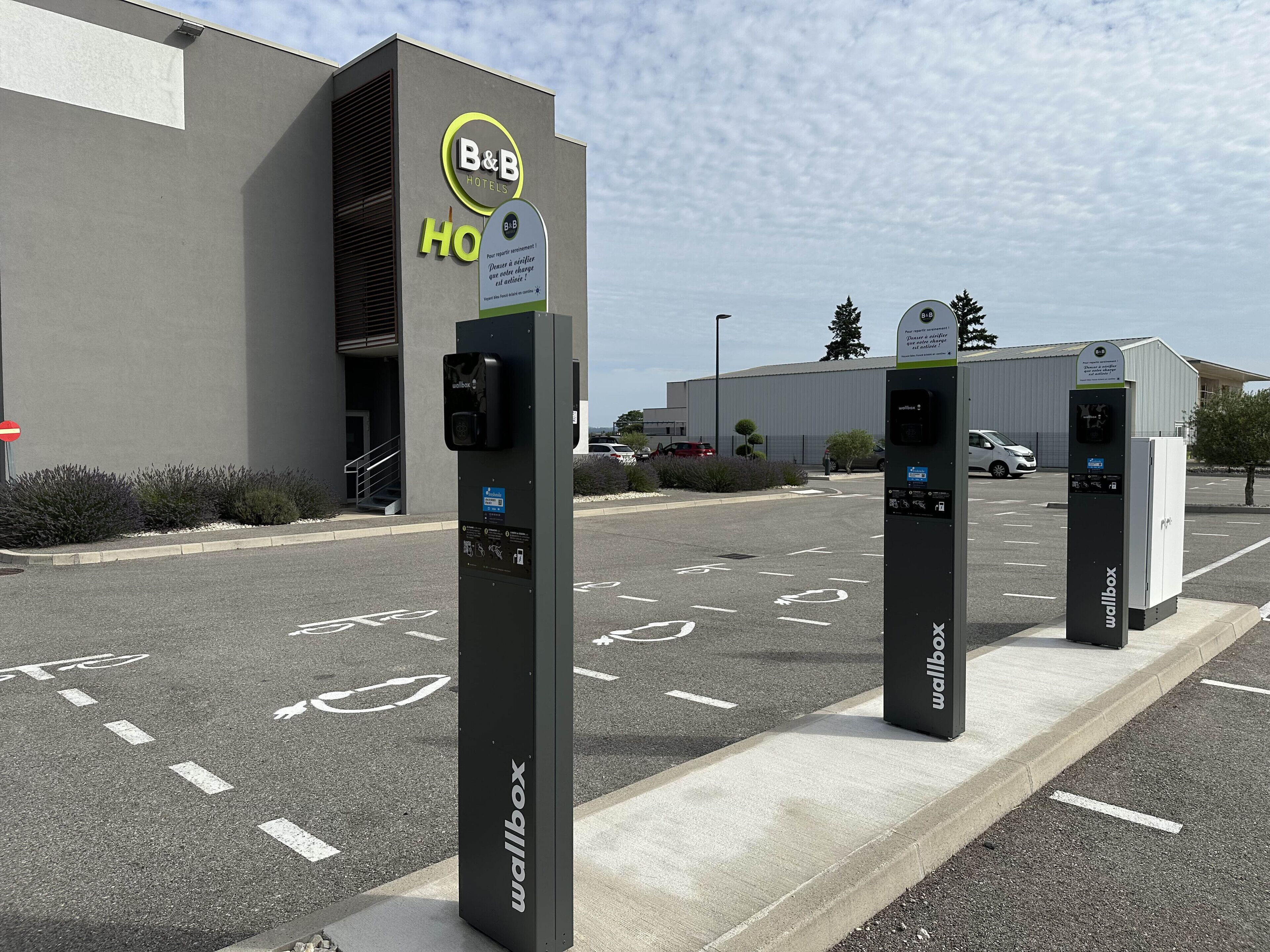 Estações de carregamento para veículos elétricos em frente a um hotel.