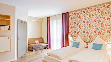 Quarto com cama de madeira, sofá, mesa pequena e guarda-roupa.