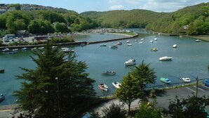 Uma marina com barcos atracados, cercada por colinas e vegetação.