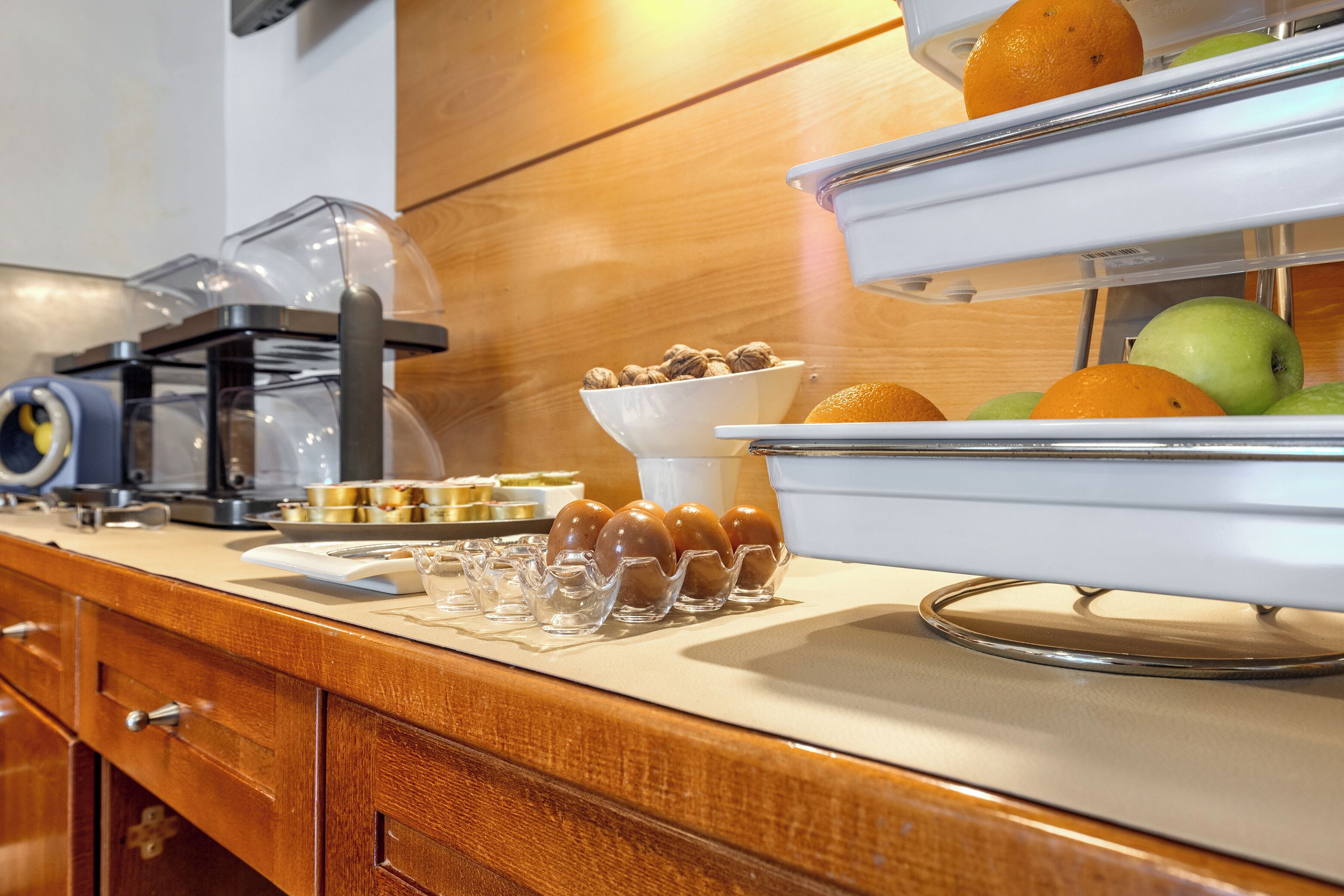 Um buffet de café da manhã com diversos alimentos e uma máquina de café.