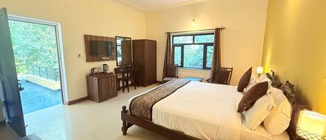 Quarto com cama, mesa de cabeceira, abajur e escrivaninha com cadeira.