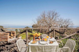 Uma área de refeições ao ar livre com uma mesa posta para dois, com vista para uma paisagem deslumbrante.