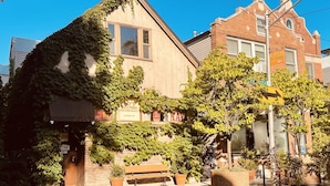 Um edifício com uma grande janela, um banco e uma placa com a inscrição "RAY'S BUCKTOWN BED & BREAKFAST".