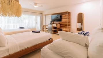 Quarto de hotel moderno com duas camas, televisão, escrivaninha e espelho.