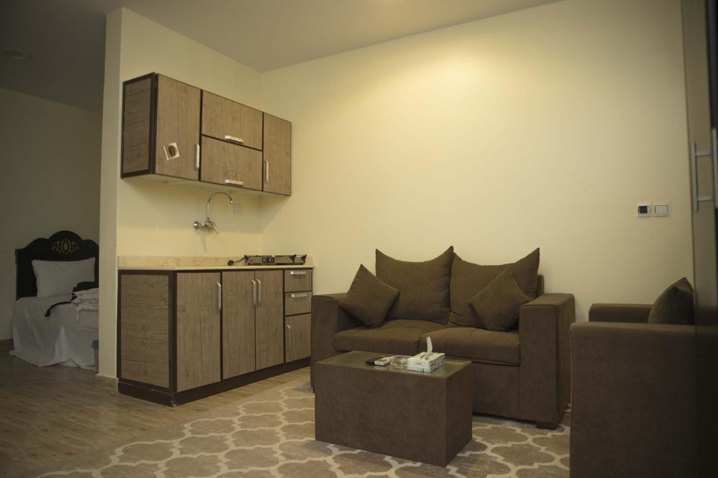 Um espaço compacto com cozinha americana, sofá e mesa de centro.