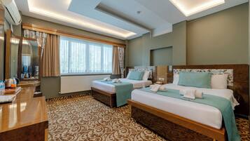 Quarto de hotel com duas camas, uma escrivaninha, um espelho e uma janela com cortinas.