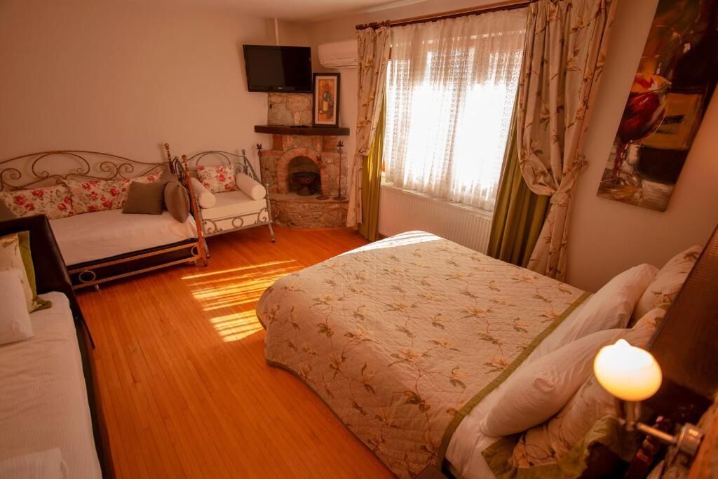 Um quarto com cama, uma cadeira, lareira e televisão.