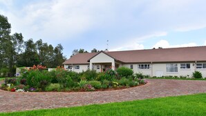 Uma casa de dois andares com um caminho de tijolos e um jardim bem cuidado.