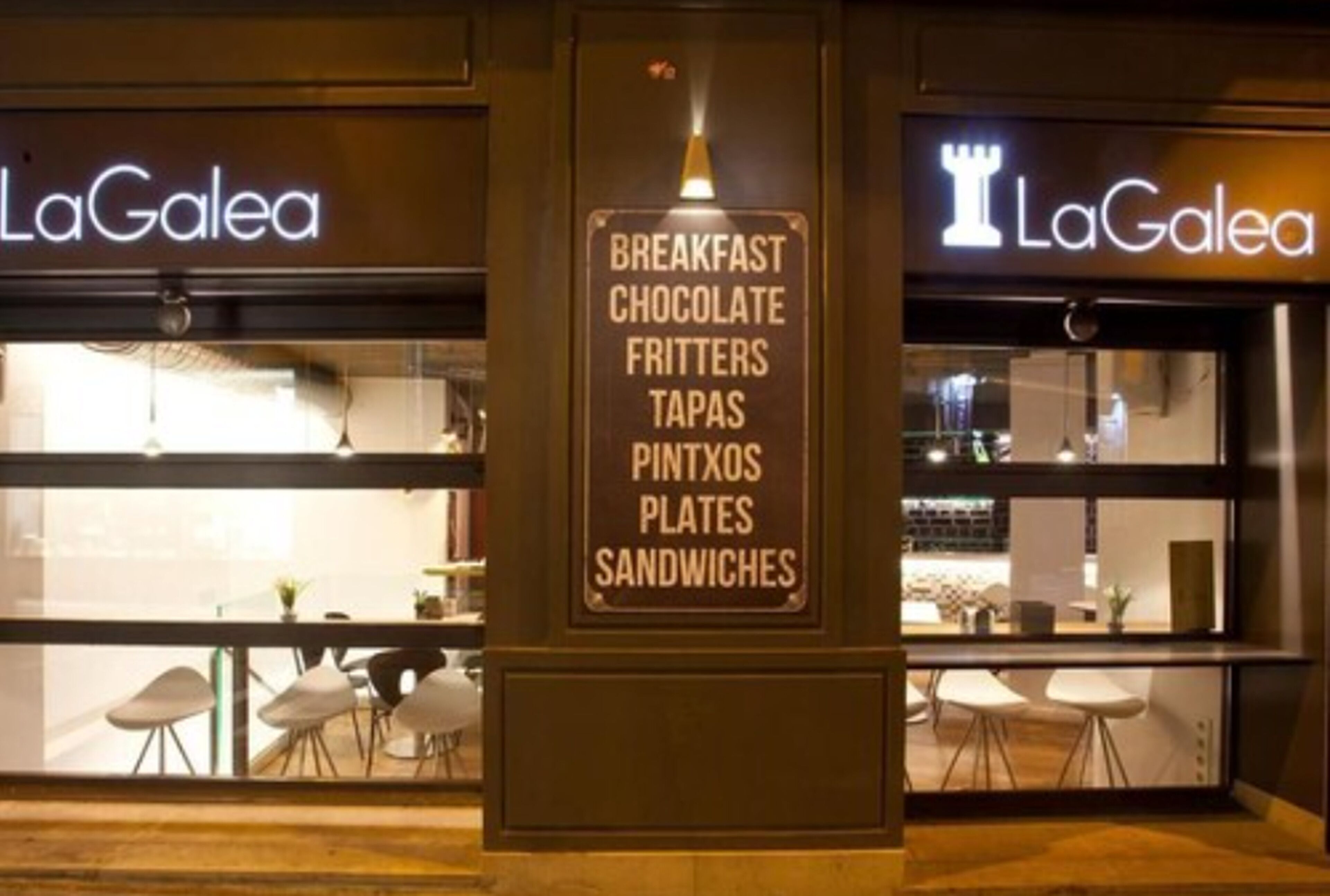 Um sinal listando opções de café da manhã na LaGalea, incluindo sonhos de chocolate, tapas, pintxos e sanduíches.