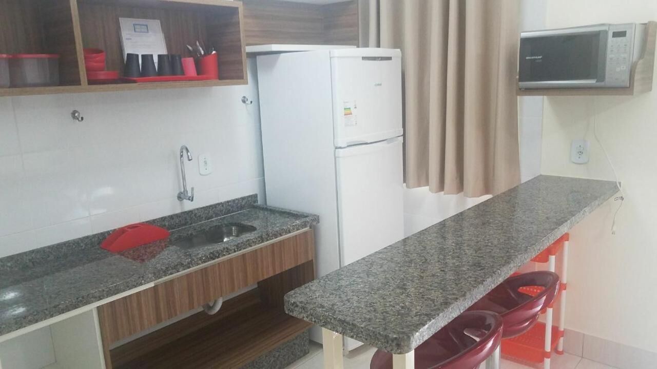 Um frigorífico, um micro-ondas, utensílios de cozinha 