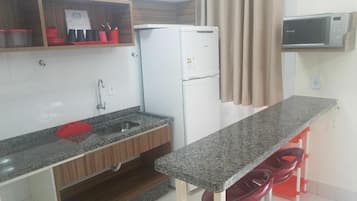 Um frigorífico, um micro-ondas, utensílios de cozinha
