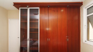 Guarda-roupa de madeira com porta deslizante e uma pequena janela.