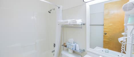 Casa de banho com banheira, sanita, lavatório e espelho com telefone.