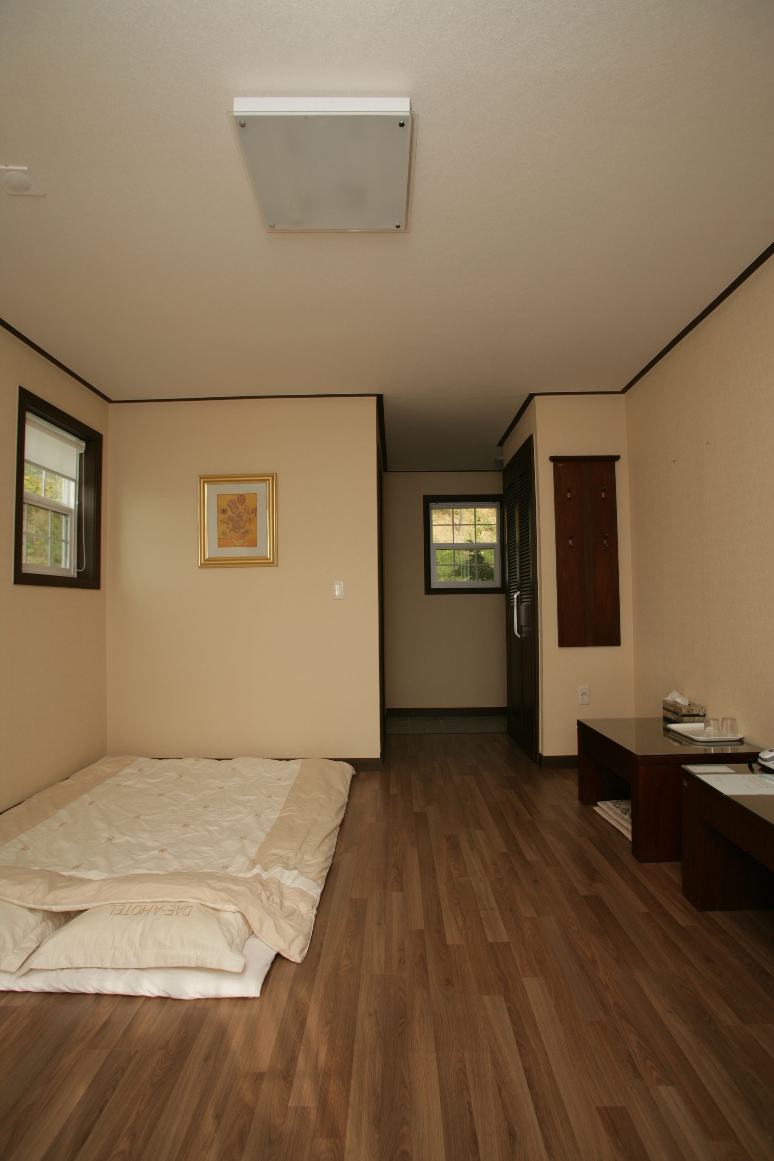 Quarto com cama, escrivaninha, janela e porta.