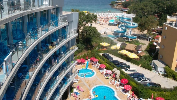 Um hotel com área de piscina, mobiliário de exterior e vista para o mar.
