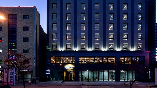 Um edifício de hotel moderno com uma placa de destaque exibindo "BENIKEA JDJANGHOTEL".