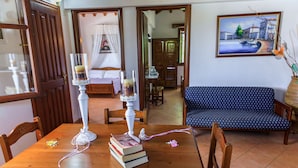 Uma área de refeições com mesa de madeira, cadeiras e sofá azul.