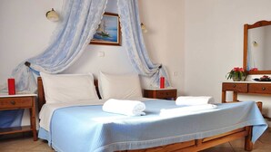 Quarto com cama, mesas de cabeceira, espelho e um quadro na parede.