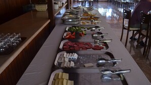 Buffet com diversos alimentos e utensílios.