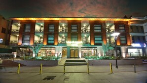 Hotel com fachada moderna, várias varandas e entrada bem iluminada.