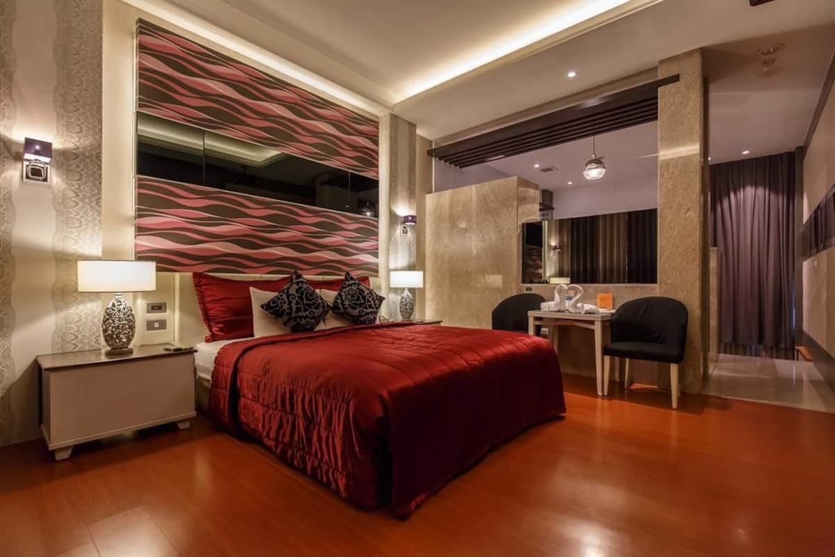 Quarto de hotel moderno com uma cama grande, uma escrivaninha e uma cadeira.