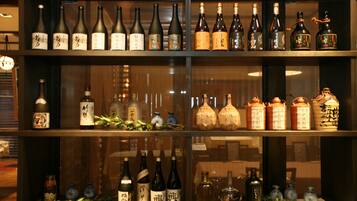 Exposição de diversos frascos e recipientes, provavelmente para bebidas, dispostos em prateleiras.