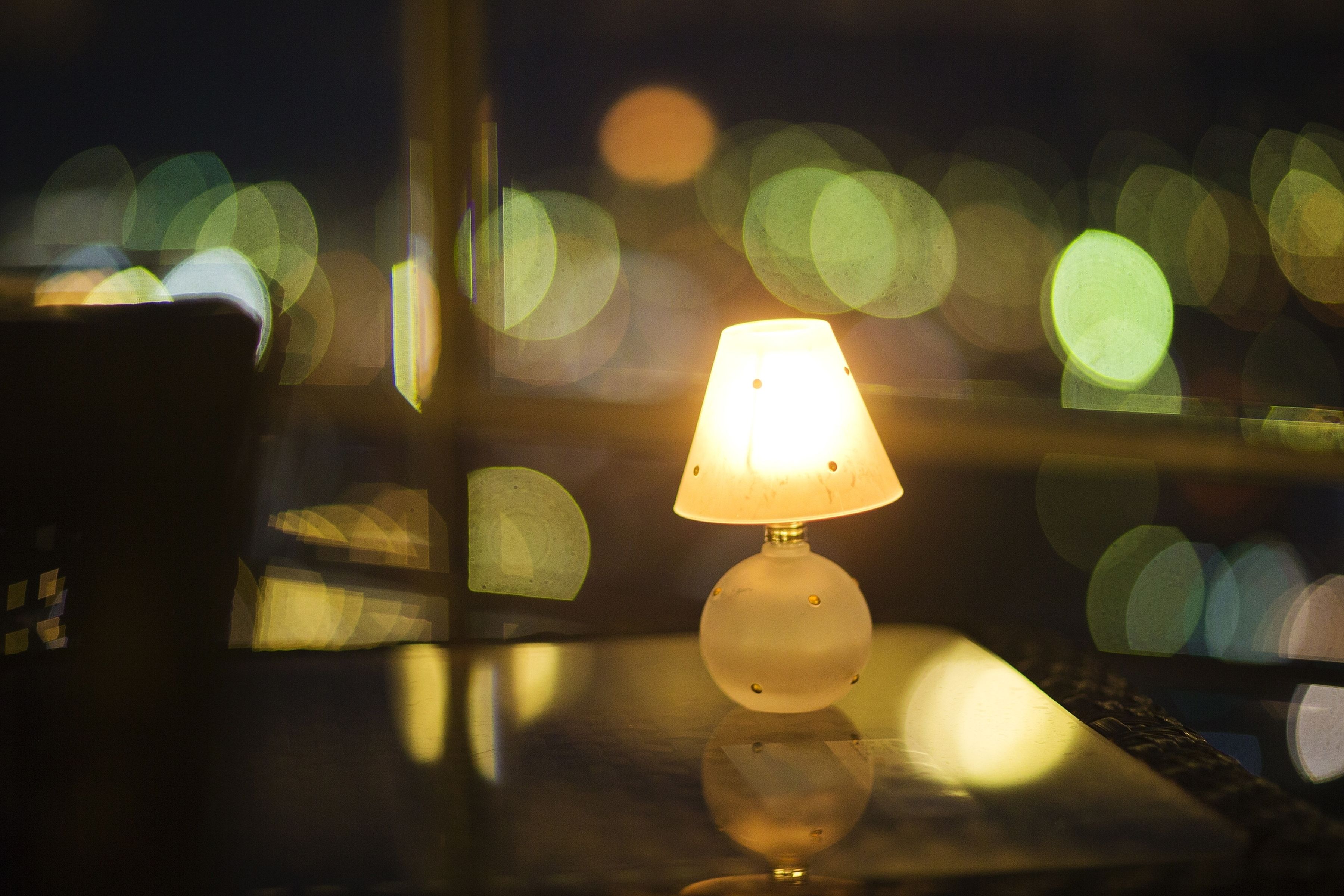 Uma mesa com uma lâmpada, refletindo luz numa superfície.
