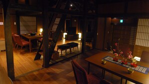 Um interior japonês tradicional com piso de esteiras de tatame, móveis de madeira e uma mesa baixa com um jogo americano.