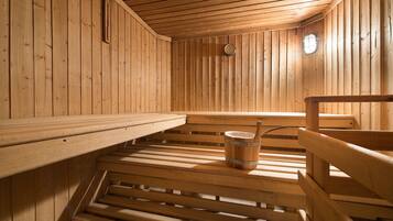 Uma sauna de madeira com bancos e um balde de madeira.
