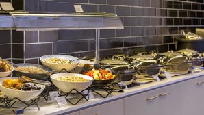 Buffet com diversos alimentos e utensílios de cozinha.