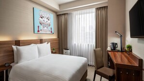 Quarto de hotel com uma cama grande, uma escrivaninha, uma cadeira, uma televisão e um quadro na parede.