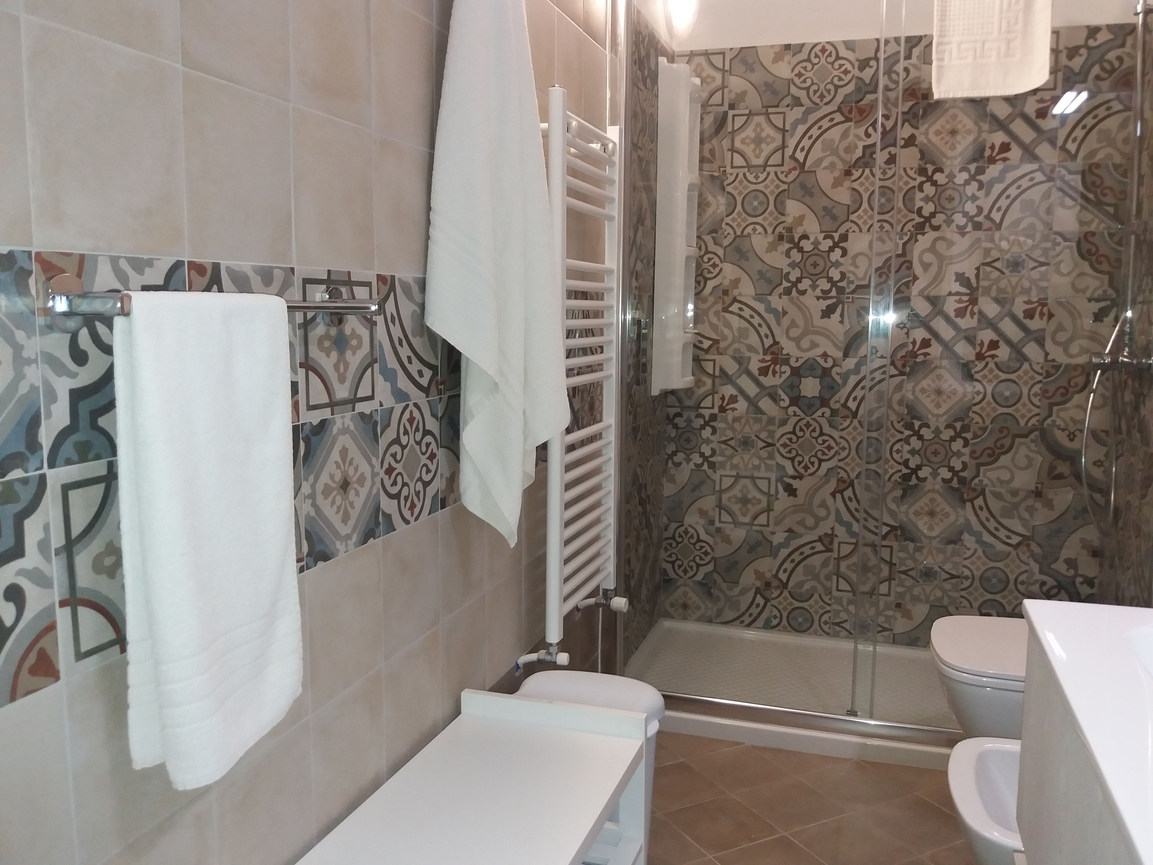 Casa de banho com chuveiro, sanita e lavatório.