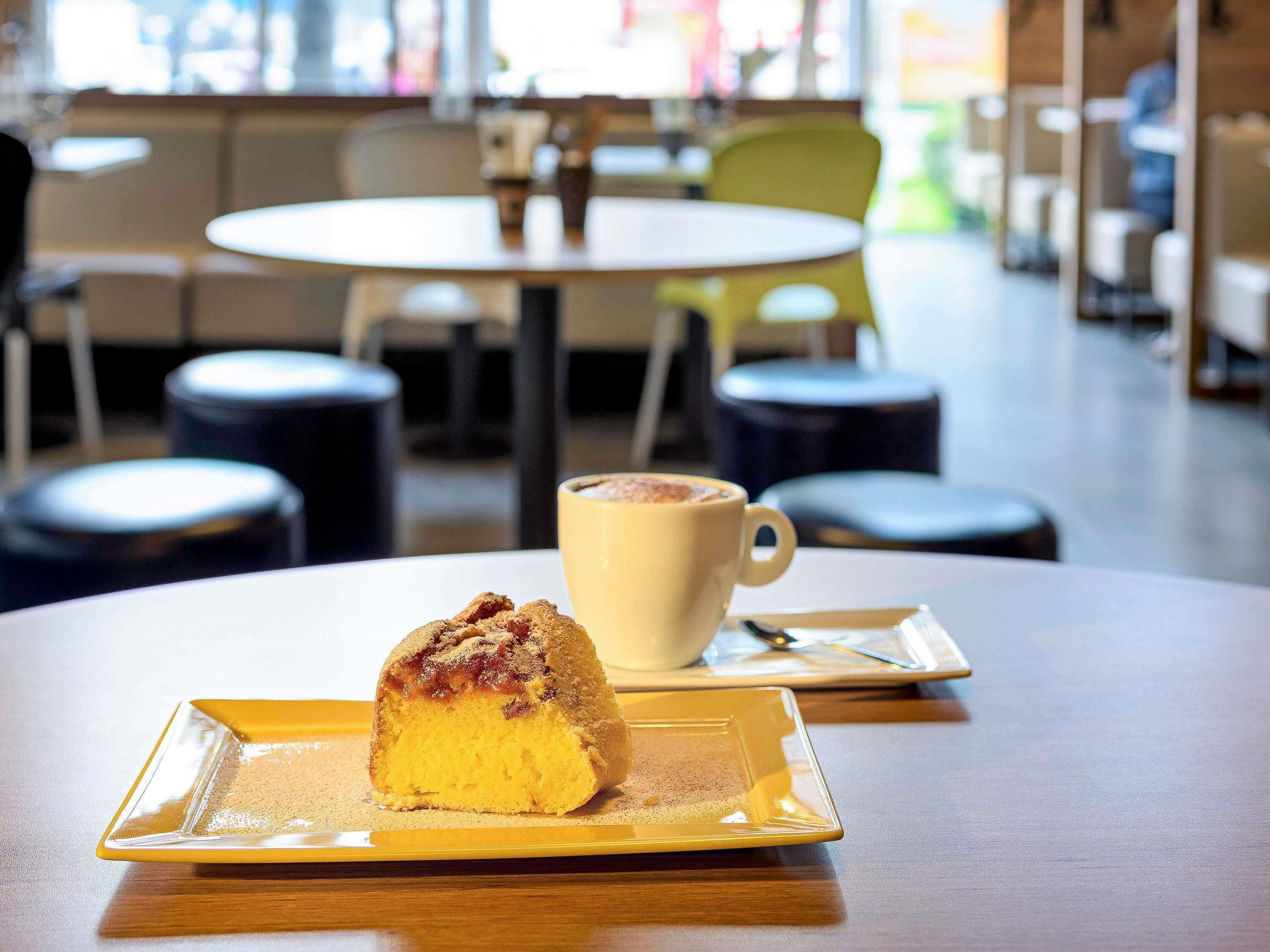Uma sobremesa num prato com uma chávena de café numa mesa num café.