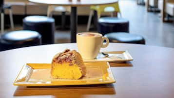 Uma sobremesa num prato com uma chávena de café numa mesa num café.