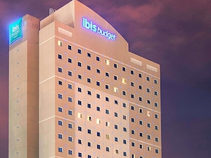 Um edifício alto com uma placa indicando 'ibis budget hotels'.