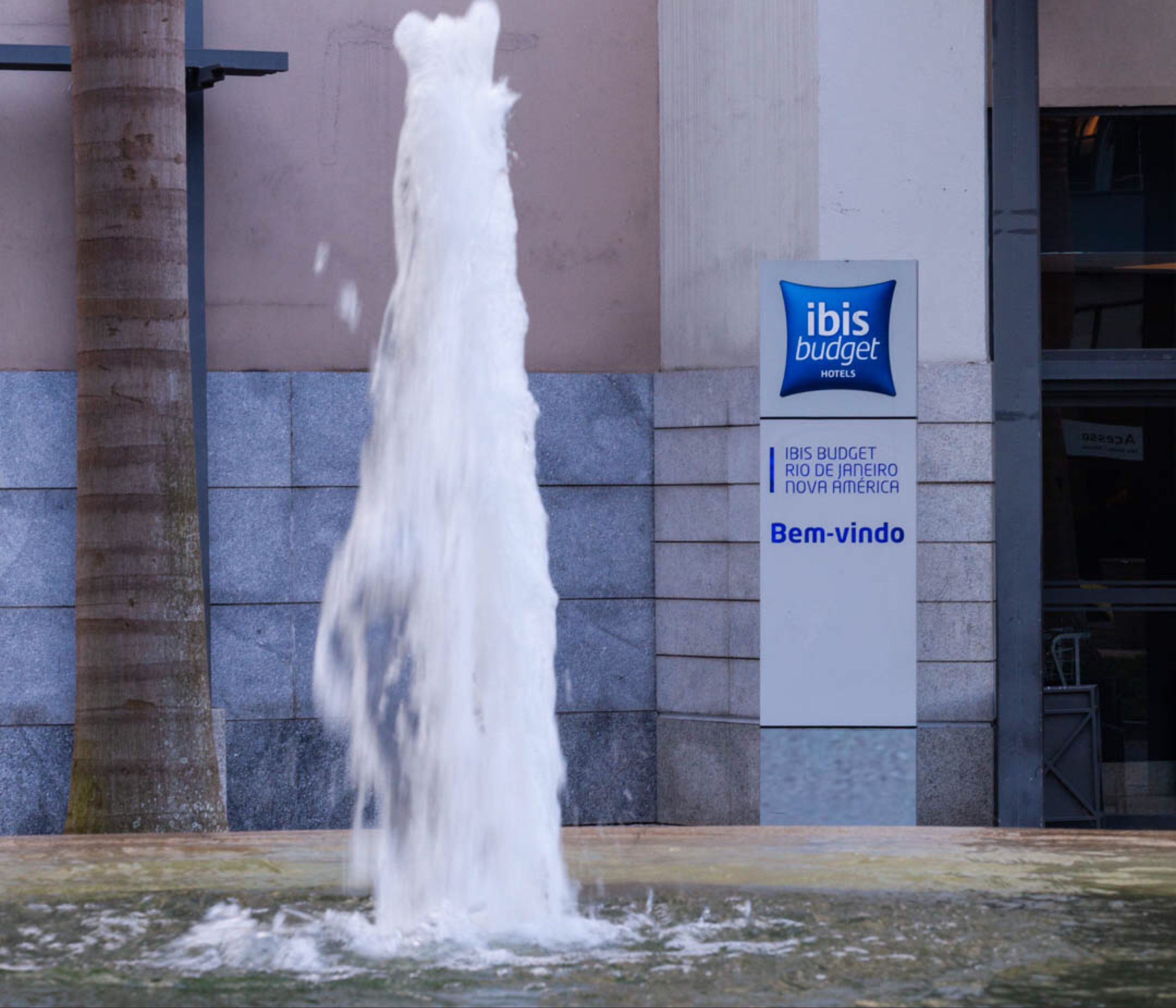 Uma fonte em frente a um edifício com a placa hotéis ibis budget.