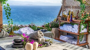 Um ambiente de spa tranquilo com uma mesa para massagem de pedra, toalhas e frascos de óleos essenciais.