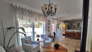 Uma sala de estar moderna com sofá, poltronas, mesa de centro e lareira.