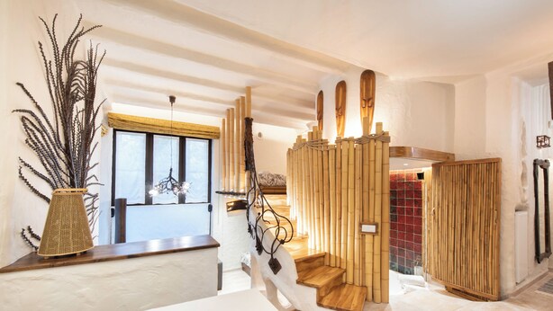 Um interior moderno com escada, balcão de recepção e planta decorativa.
