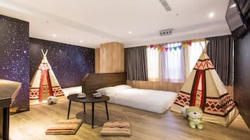 Um quarto aconchegante com uma cama, uma mesinha, dois tipi decorativos e um brinquedo macio.