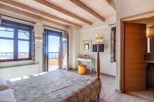 Quarto com uma cama grande, uma escrivaninha e um guarda-roupa.