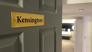 Quarto de hotel com uma placa na porta com o nome 'Kensington'.