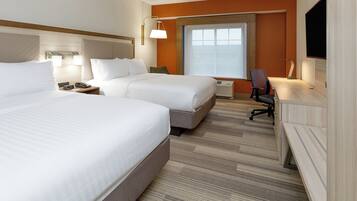 Quarto de hotel com duas camas, uma escrivaninha, uma cadeira, uma televisão e uma janela.