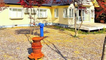 Um edifício amarelo com janelas brancas e uma caixa de correio azul.
