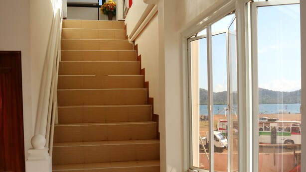 Uma escadaria com vista para um corpo de água e veículos ao longe.