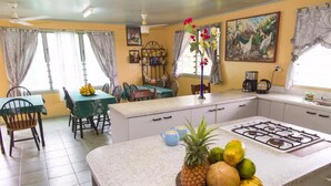 Cozinha com ilha central, área de refeições e um quadro na parede.