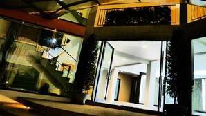 Um edifício moderno com fachada de vidro, escadaria e uma grande janela.