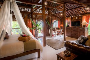 Um quarto amplo com cama, sofá, televisão e área de refeições.